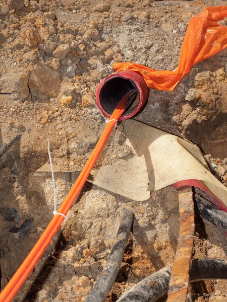 Excavation of trench with black cables in protective HDPE tube. Lines ...