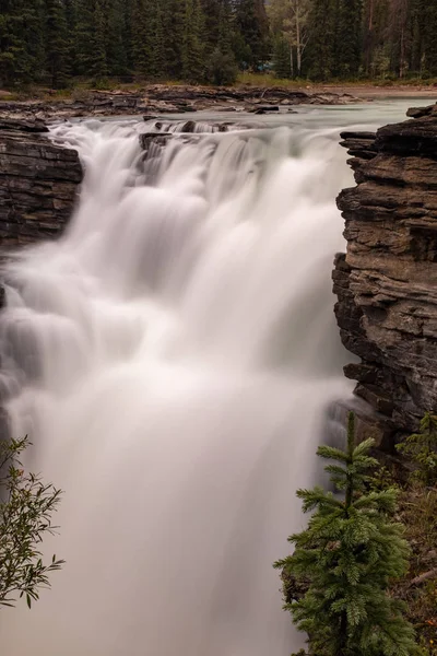 A distant view of a majestic waterfall in Monkman Provincial Park ...