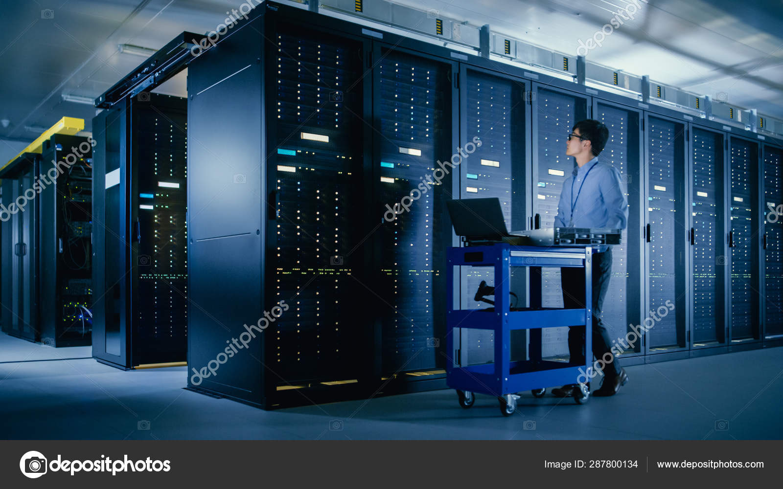 In the Modern Data Center: IT Engineer Doing Maintenance and ...