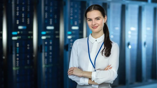 Female IT Specialist is standing at the Camera in Data Center Next to ...