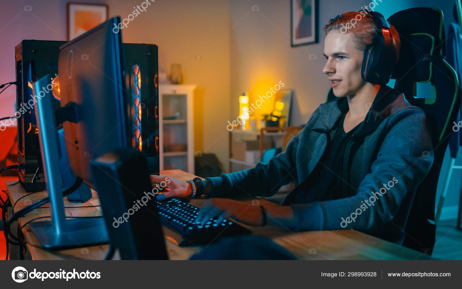 Happy Gamer in Headset with a Mic Playing Shooter Online Video Game on His Personal Computer ...