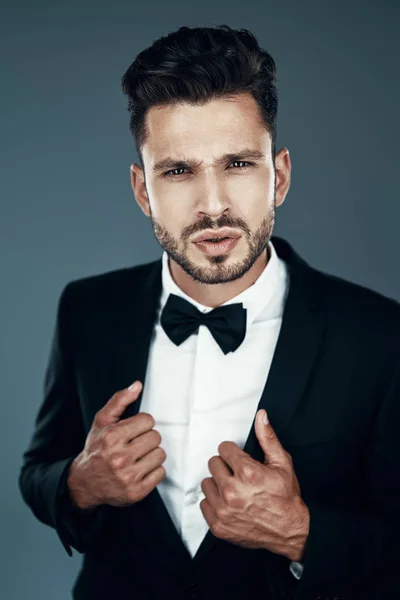 Charming young man in bow tie looking at camera and keeping hand on ...
