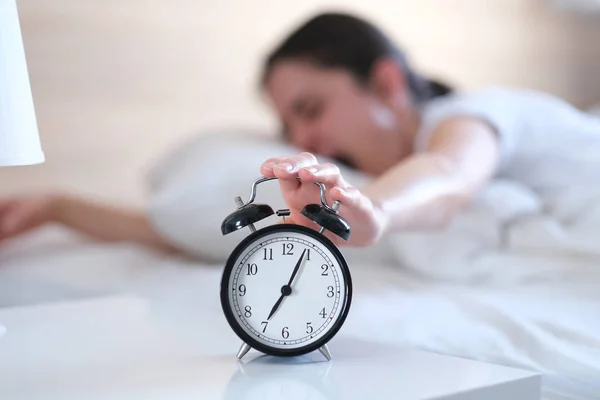 Young woman is not ready to wake up.Alarm o'clock. Time to wake up ...