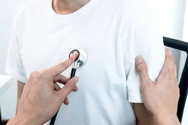 Male doctors perform a pulse examination using a stethoscope. Initial ...