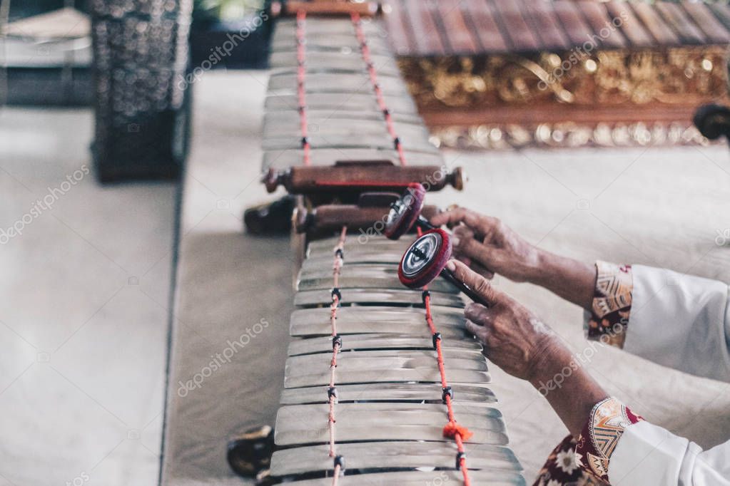 Un hombre usa batik y blankon jugando gamelan Gender o Slenthem ...