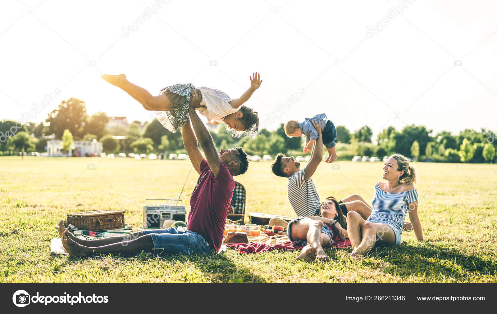 Young multiracial families having fun playing with kids at pic nic ...
