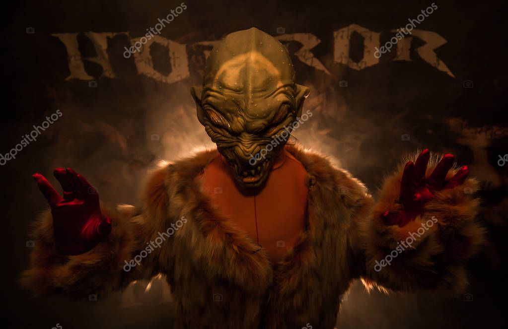 monstruo de miedo en la piel posando a la cámara contra el fondo ...