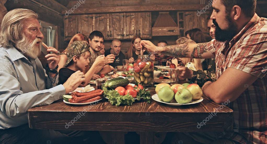 Gran grupo de amigos y familiares sentados en la cabaña de los ...