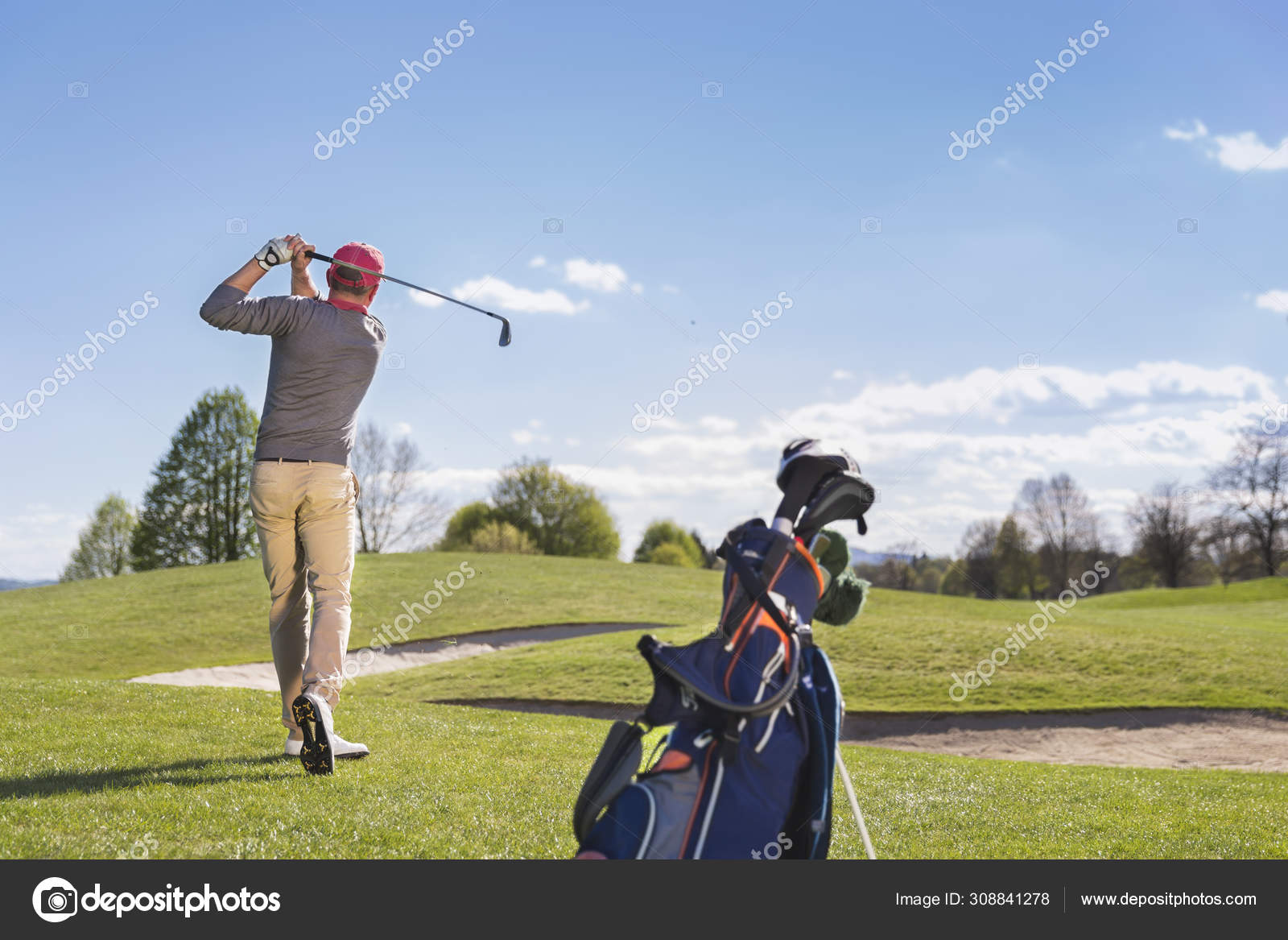 Young man playing golf on course. — Stock Photo © lichtmeister #308841278