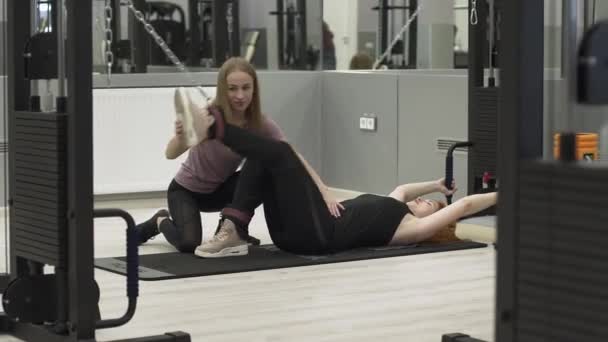 Sports red-haired woman is engaged in the gym with an individual ...