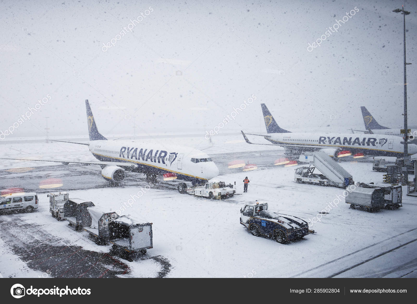 Airplanes on the runway are covered by snow during a snowfall at ...