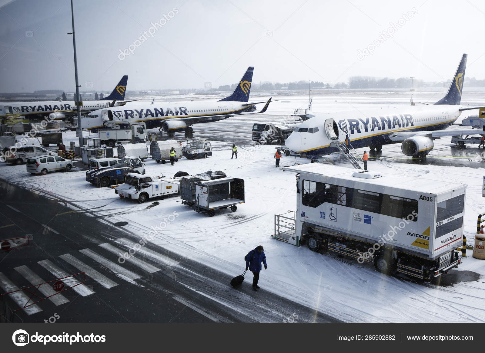 Airplanes on the runway are covered by snow during a snowfall at ...