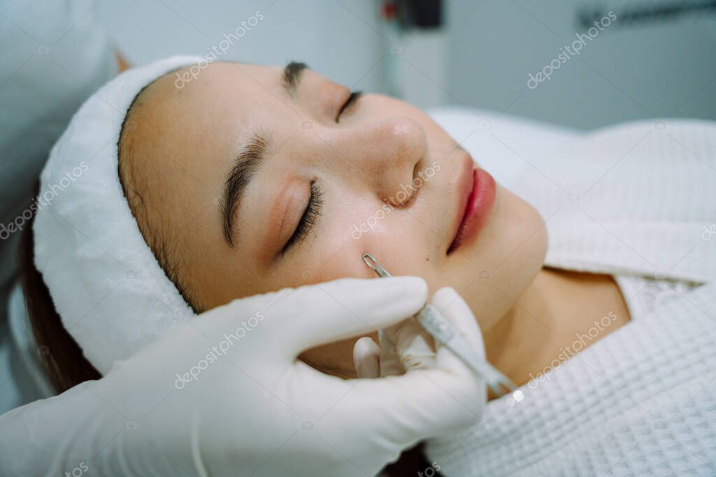esteticista utilizando equipos de limpieza del acné en la cara de la ...