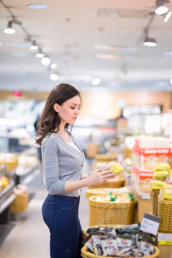 Mujer eligiendo productos diarios en el supermercado. Leer la informaci n del producto.Concepto ...