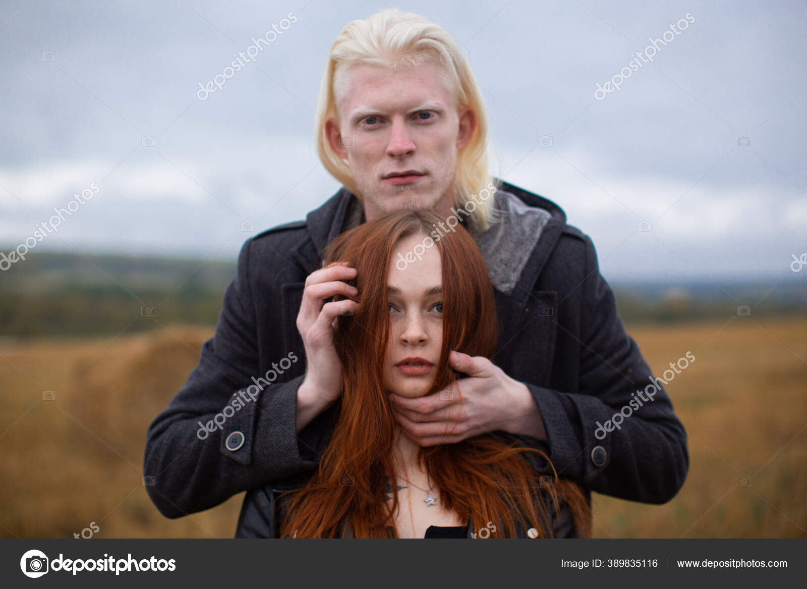 The colourful couple pose while staring at the camera on a wheat field ...