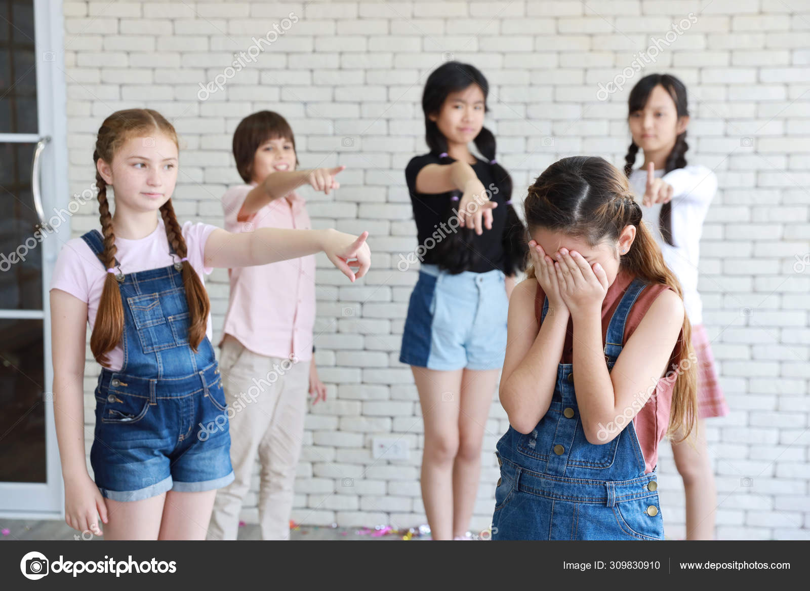 Group of school kids pointing to cute girl which crying in class ...