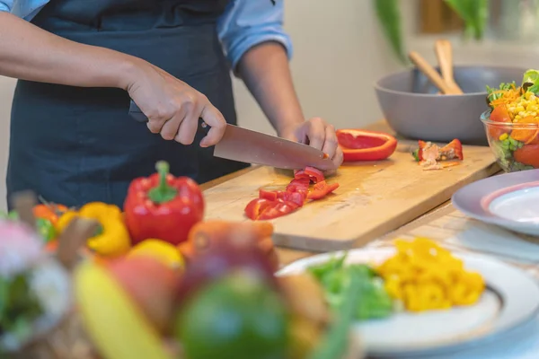 Closeup chef hand cutting the bell pepper on the Chopping board in ...