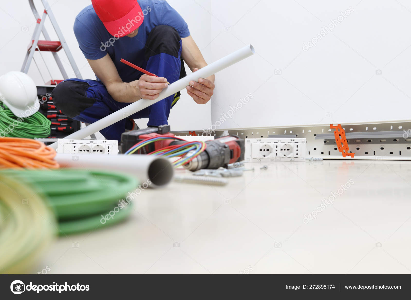 Electrician at work with pencil in hand measures the plastic pip ...