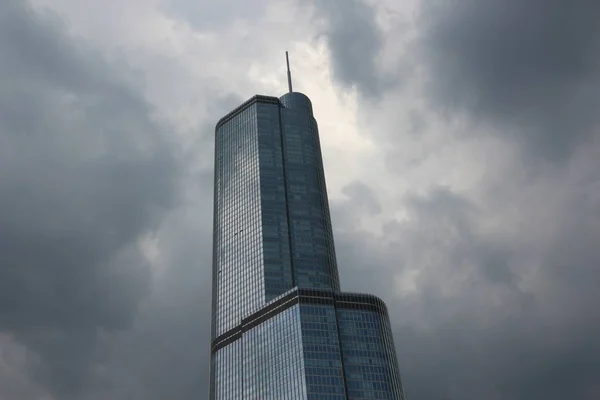 Low angle shot of a gray skyscraper under a cloudy sky - Stock Image ...