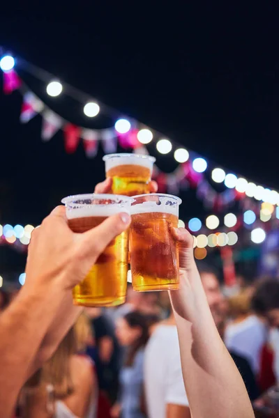 Friends drinking beer at night with de-focused lights in the bac ...