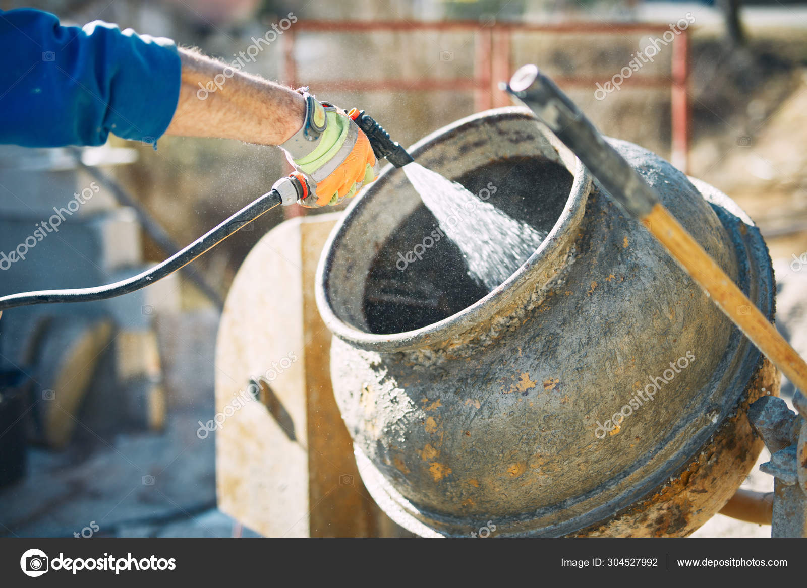 Construction worker on a cement / concrete mixer cleaning remain Stock ...