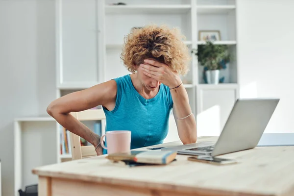 Woman working from home and being depressed, tired with headache ...
