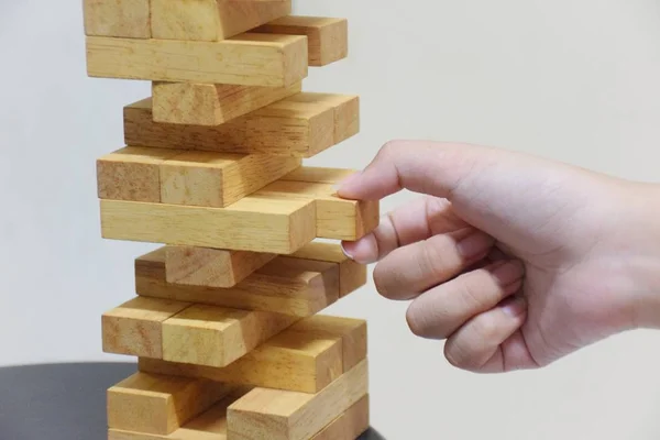 Hand take one block from wooden block game - Stock Image - Everypixel