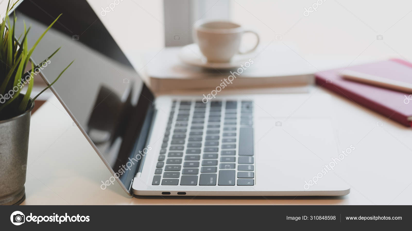 Comfortable workplace with open laptop computer, coffee cup and office ...