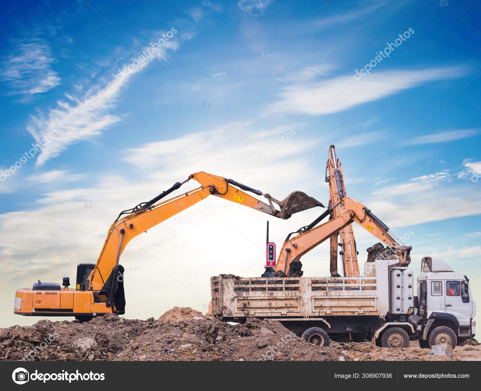 Loader excavator moving earth and unloading into a dumper truck Stock ...