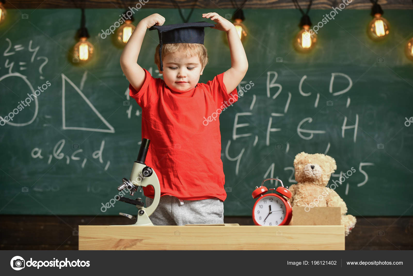 Child, pupil on calm face with mortarboard. Kid boy in graduate cap ...