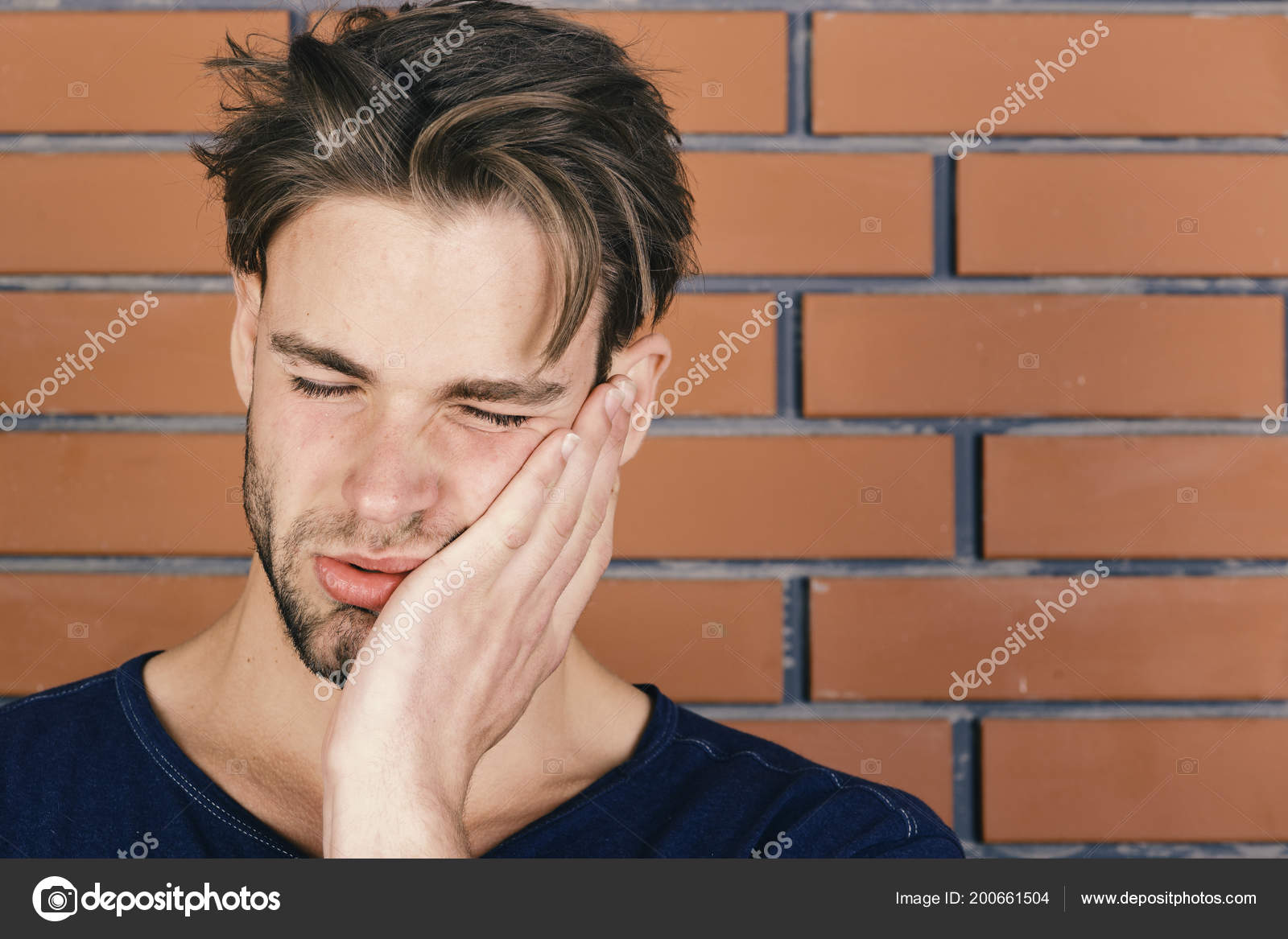 Macho with suffering face holds hand on cheek Stock Photo by ©stetsik ...