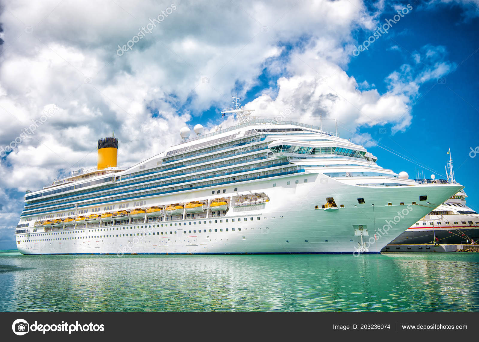 Cruise ship at sea dock in turquoise sea on cloudy blue sky. Travelling ...