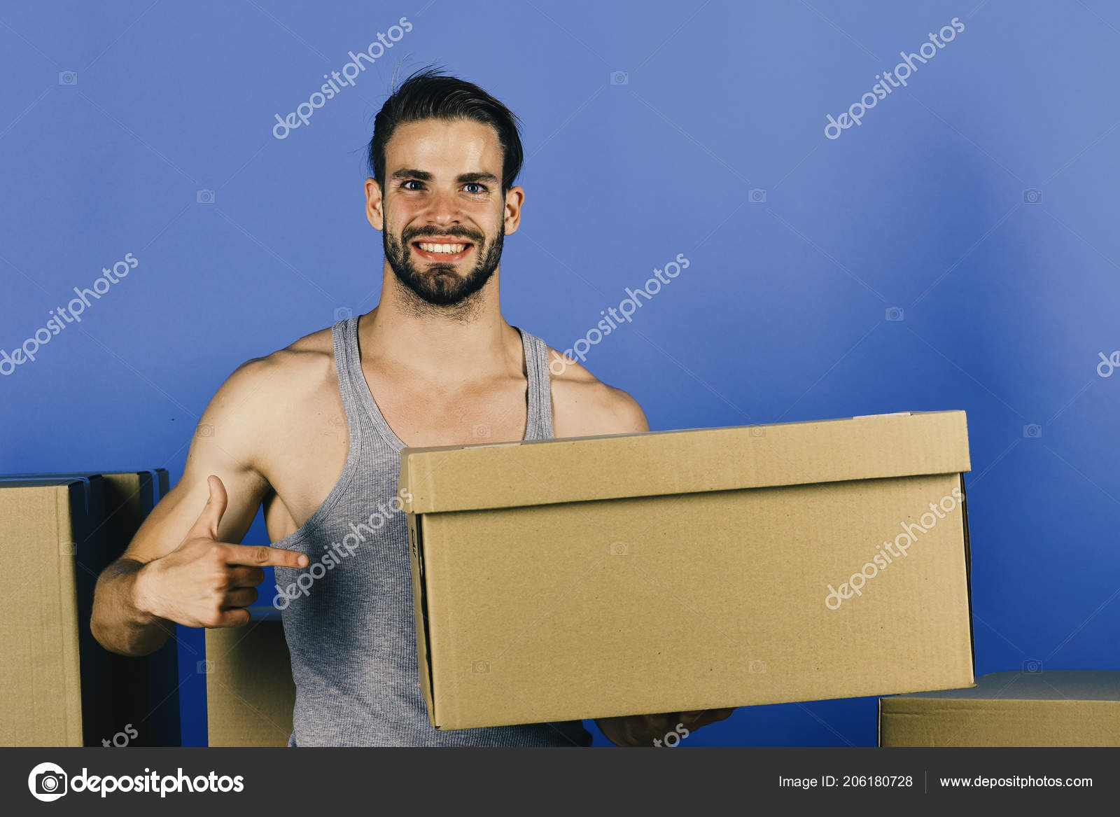 Man standing among cardboard boxes and holding one. Delivery and moving ...