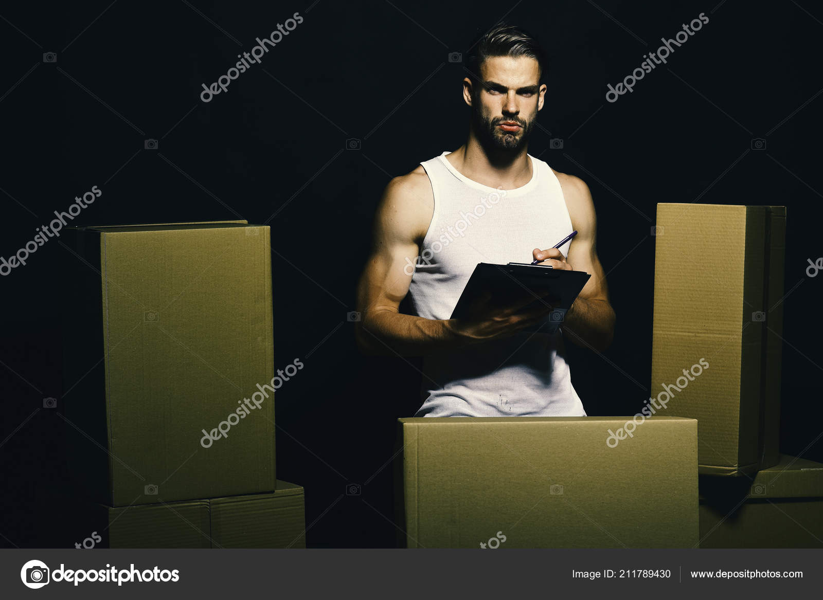 Guy with muscular hands stands among boxes. Stock Photo by ©stetsik ...