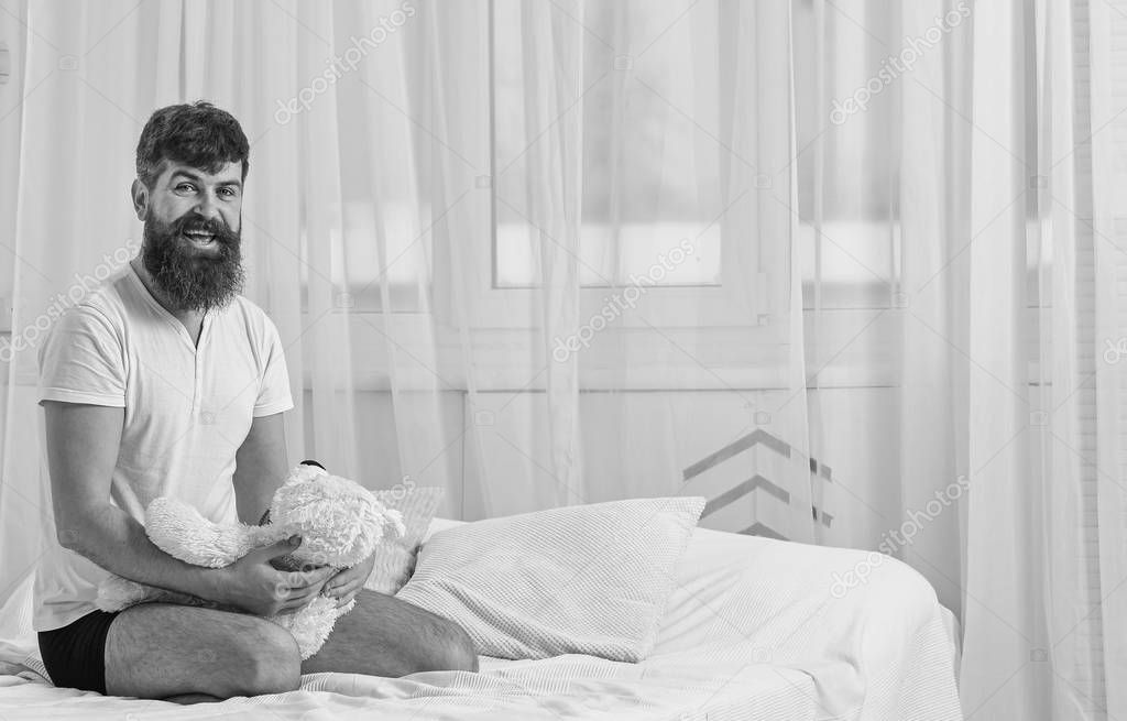 Un tipo sonriente jugando con un osito de peluche. Concepto de ...