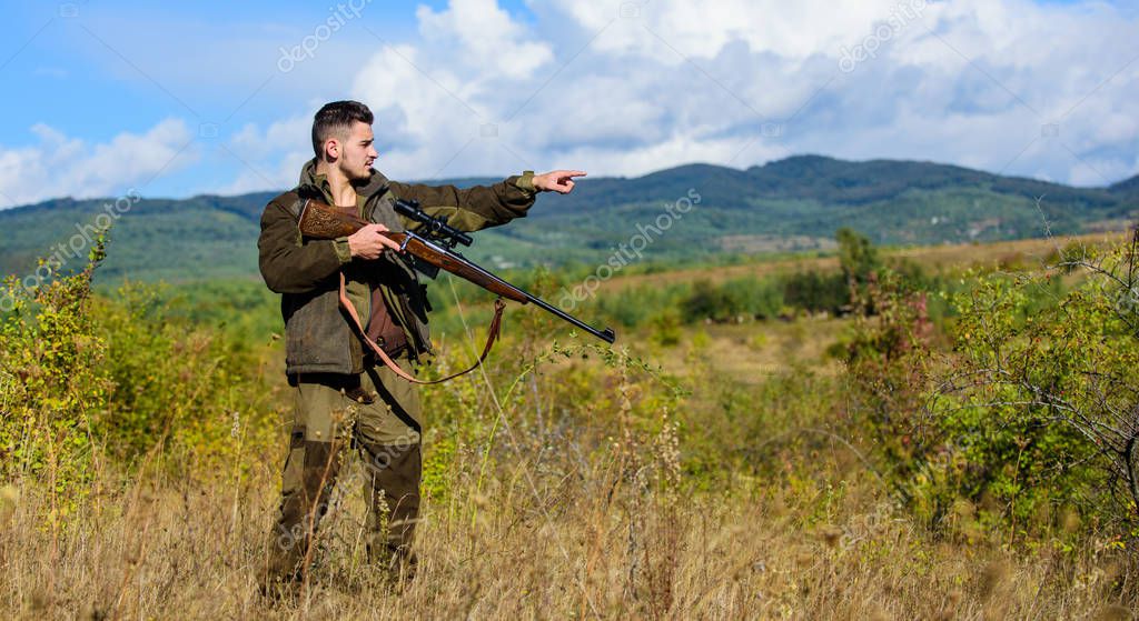 Hombre cazador apuntando rifle naturaleza fondo. La experiencia y la ...