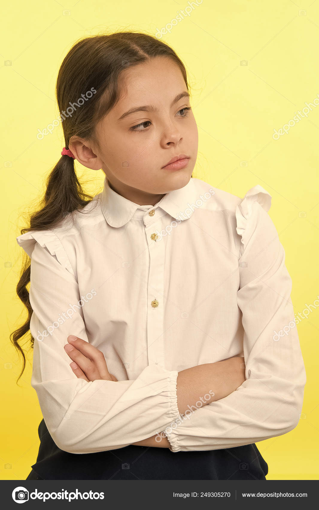 Not in her best mood. Girl school uniform serious face offended yellow ...
