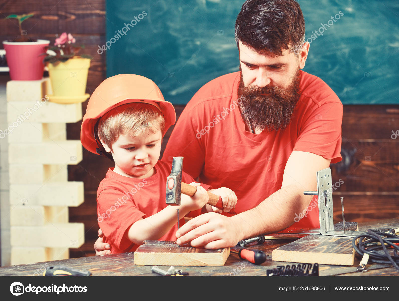 Handyman concept. Father with beard teaching little son to use tools ...