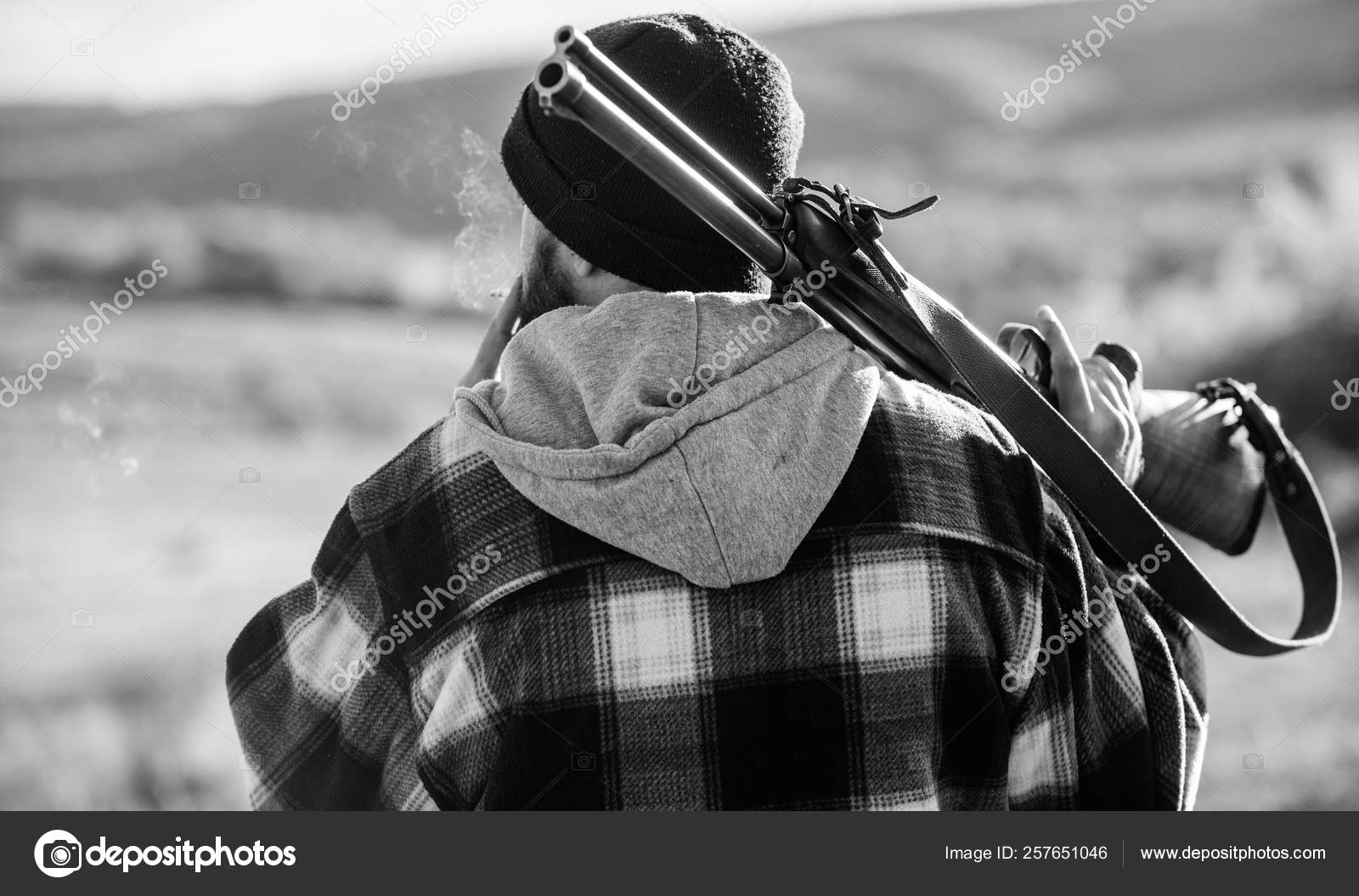 Brutality and masculinity. Hunter carry rifle gun on shoulder rear view ...