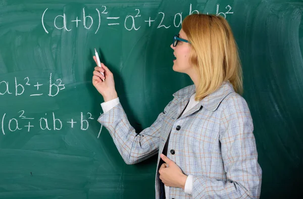 Focused on exam. teacher on school lesson at blackboard. woman in ...