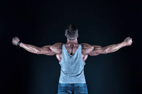 Increasing muscle mass through exercise. Muscle man back view on black ...