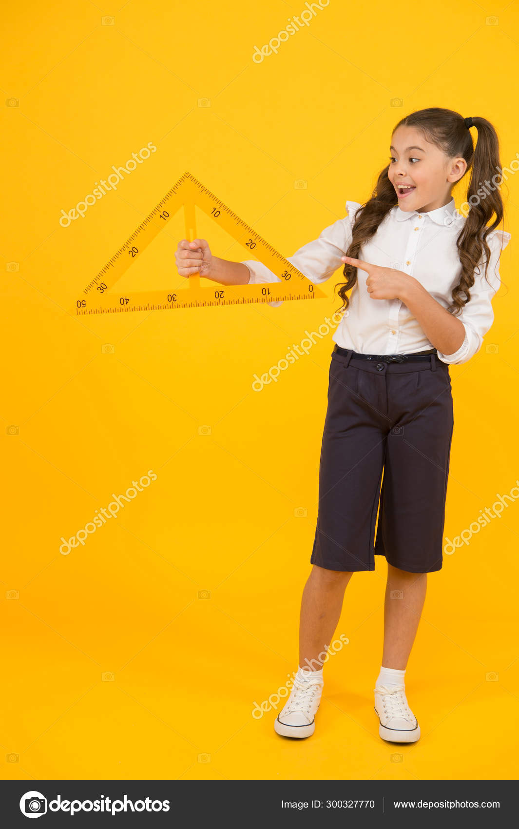 Look at the triangle with two equal sides. Happy little schoolgirl ...