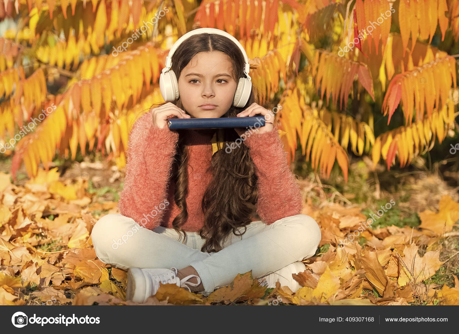 ELearning today. Little girl learning online under tree with yellow ...