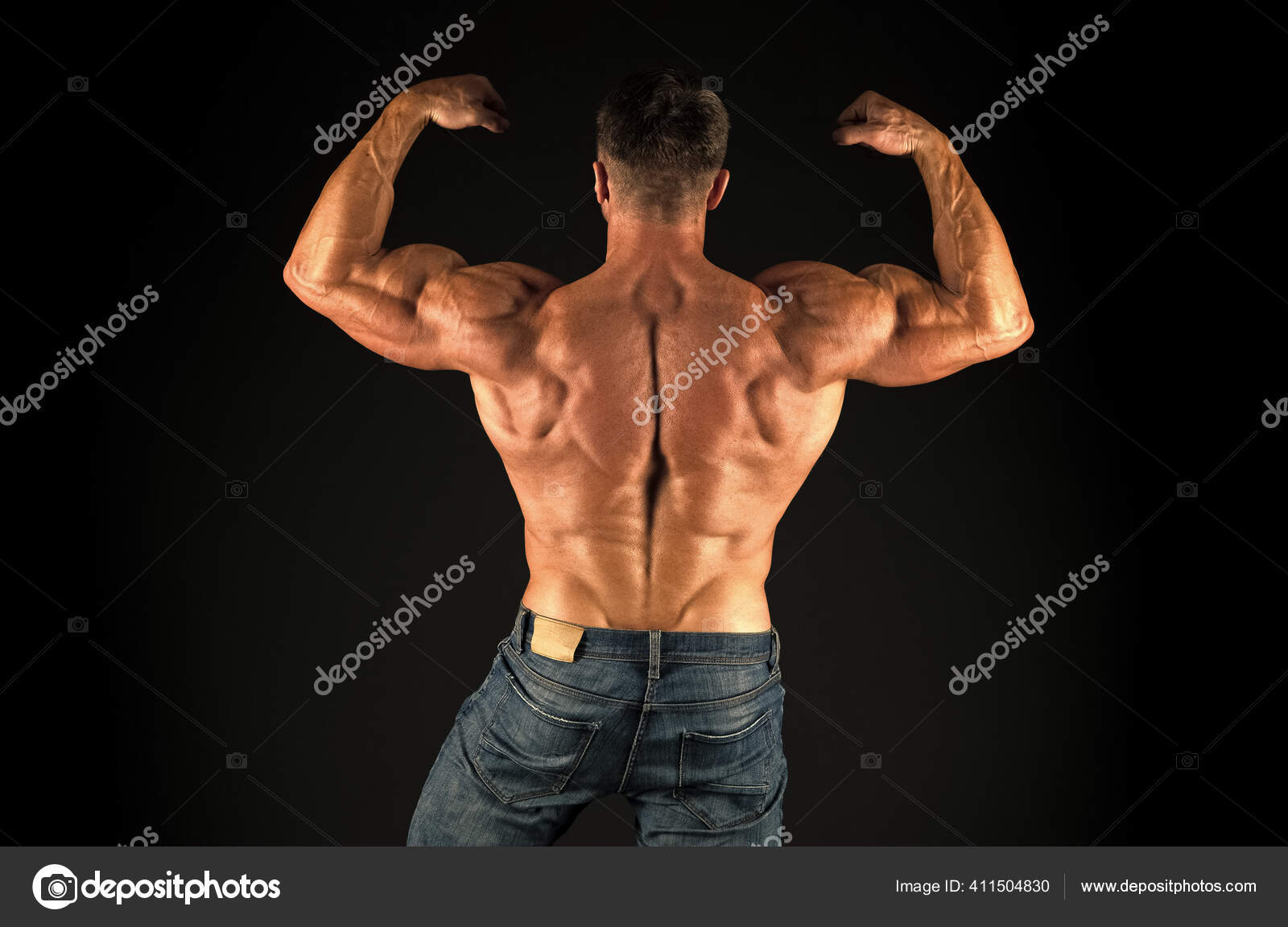 Bodybuilder perfect shape rear view. Strong bodybuilder flexing arms ...