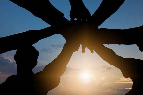 unity and teamwork concept, silhouette of group people putting hand ...