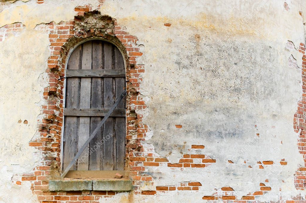 pared de un viejo edificio abandonado y tapiado por la ventana 2023