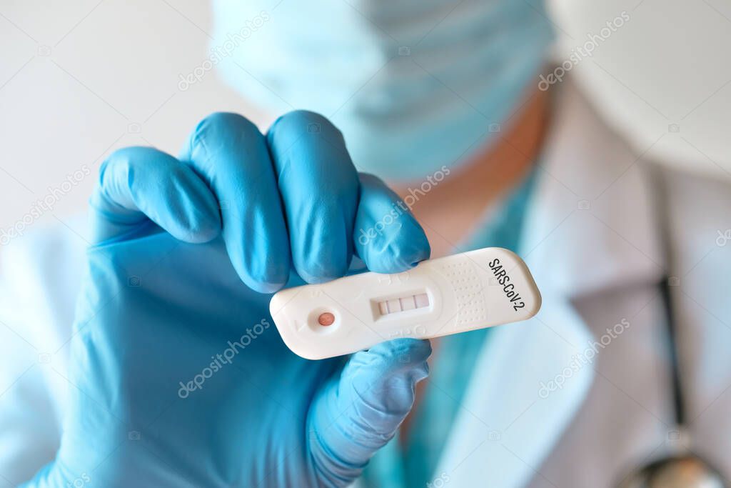 El médico muestra una banda de prueba rápida de laboratorio COVID-19 ...