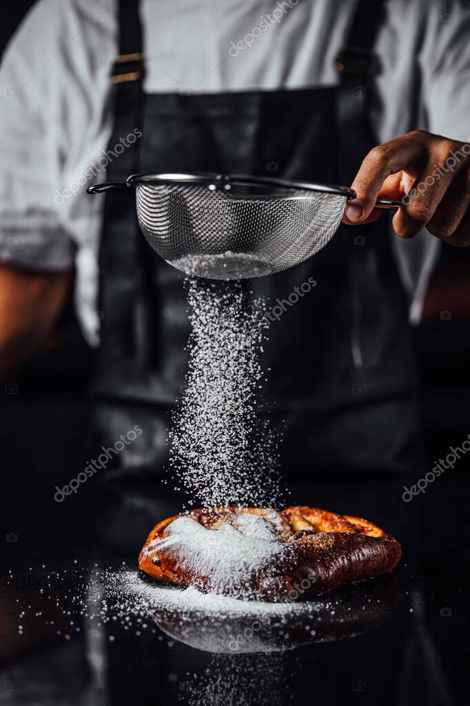Chef de confitería haciendo dulces, las manos del hombre espolvorean ...