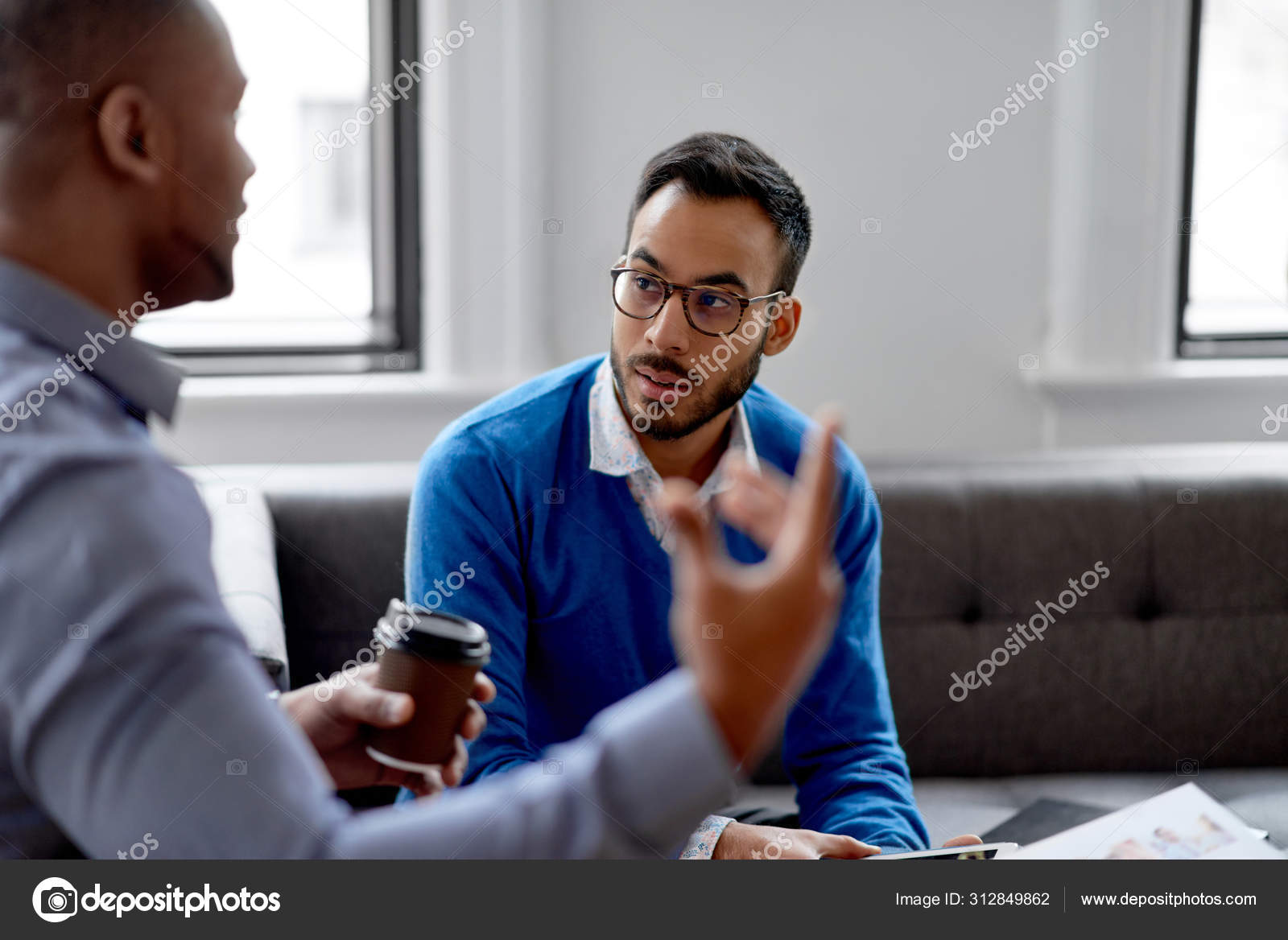 Indian businessman leading a team of creative millenials collaborating ...