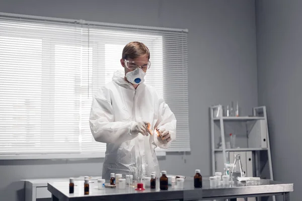 A scientific researcher setting on fire the material he is testing ...